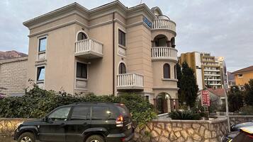 Um hotel com vários andares, varandas, uma parede de pedra e uma placa com o nome Lux Hotel.