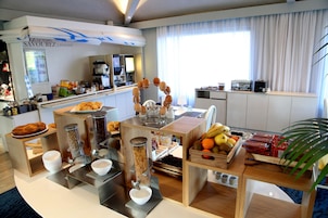 Uma cozinha moderna com espaço para café, bancada para refeições e diversos alimentos.