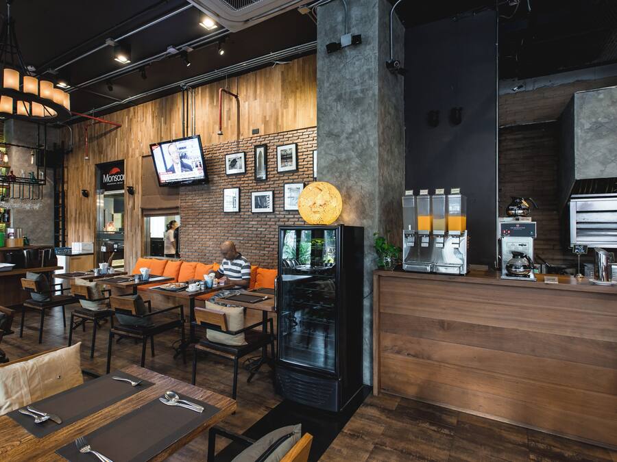 Um café moderno com paredes de madeira, uma televisão na parede e uma máquina de café.