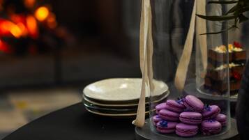 Uma cúpula de vidro com macarons roxos e uma pequena planta.