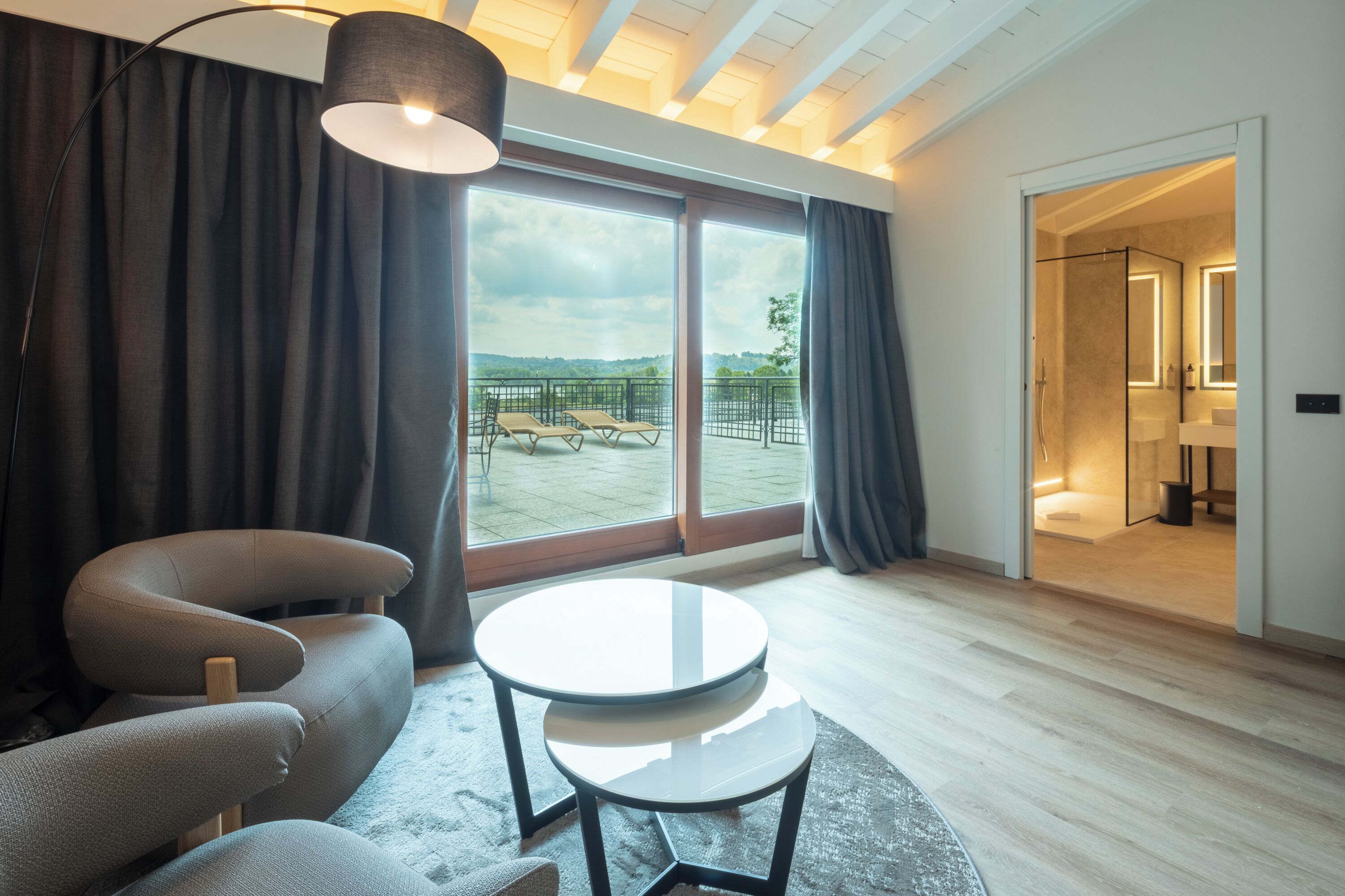 Quarto moderno com grande porta de vidro deslizante, mesa redonda e sofá.