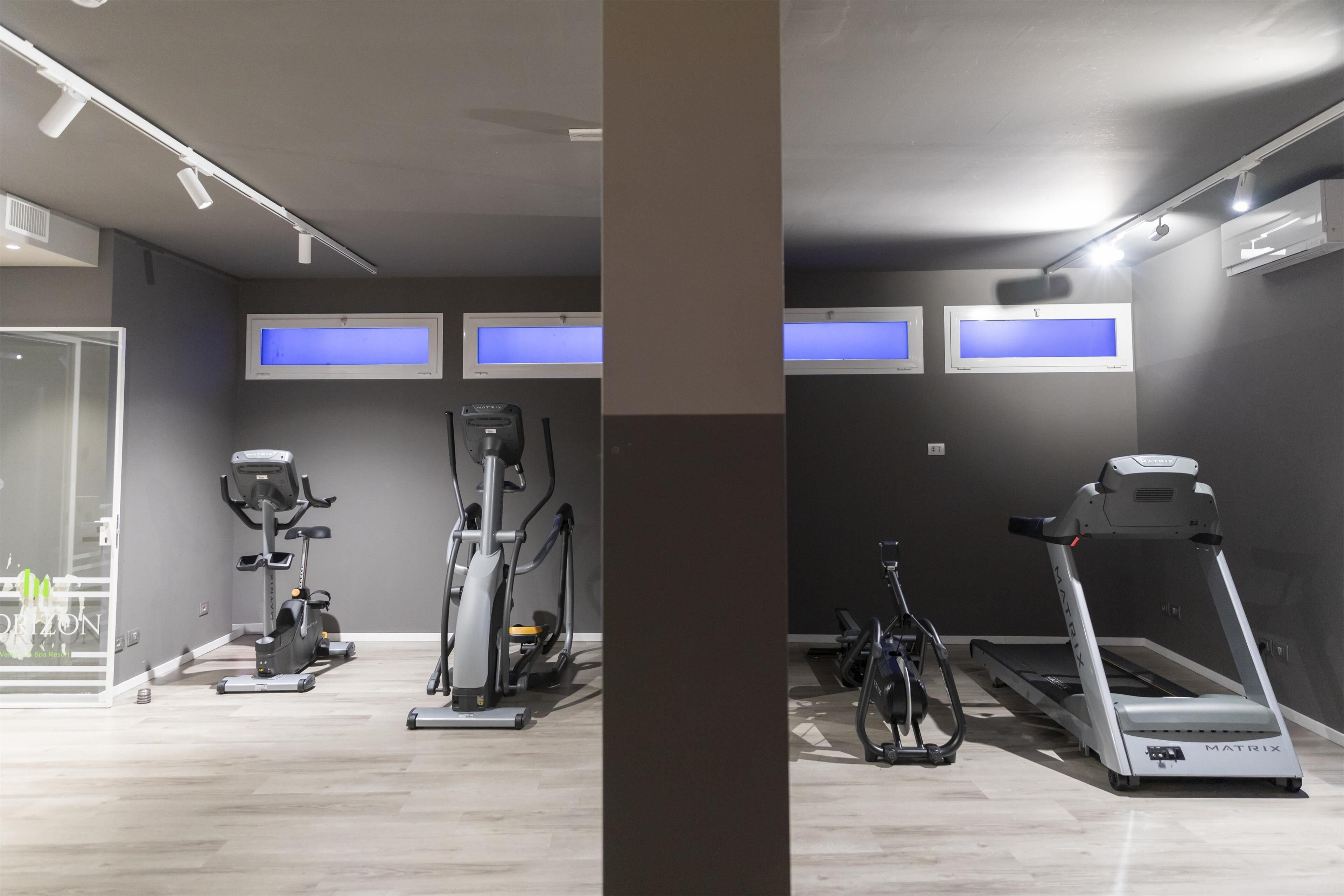 Uma academia com esteiras, elípticos e bicicletas ergométricas.