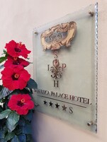 Placa do Hotel San Luca Palace, com um emblema decorativo e um desenho floral.