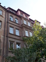 Um edifício de vários andares com grandes janelas e estilo arquitetônico clássico.