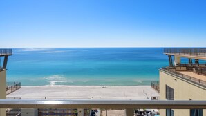 Vista da praia a partir de uma varanda, com céu limpo.