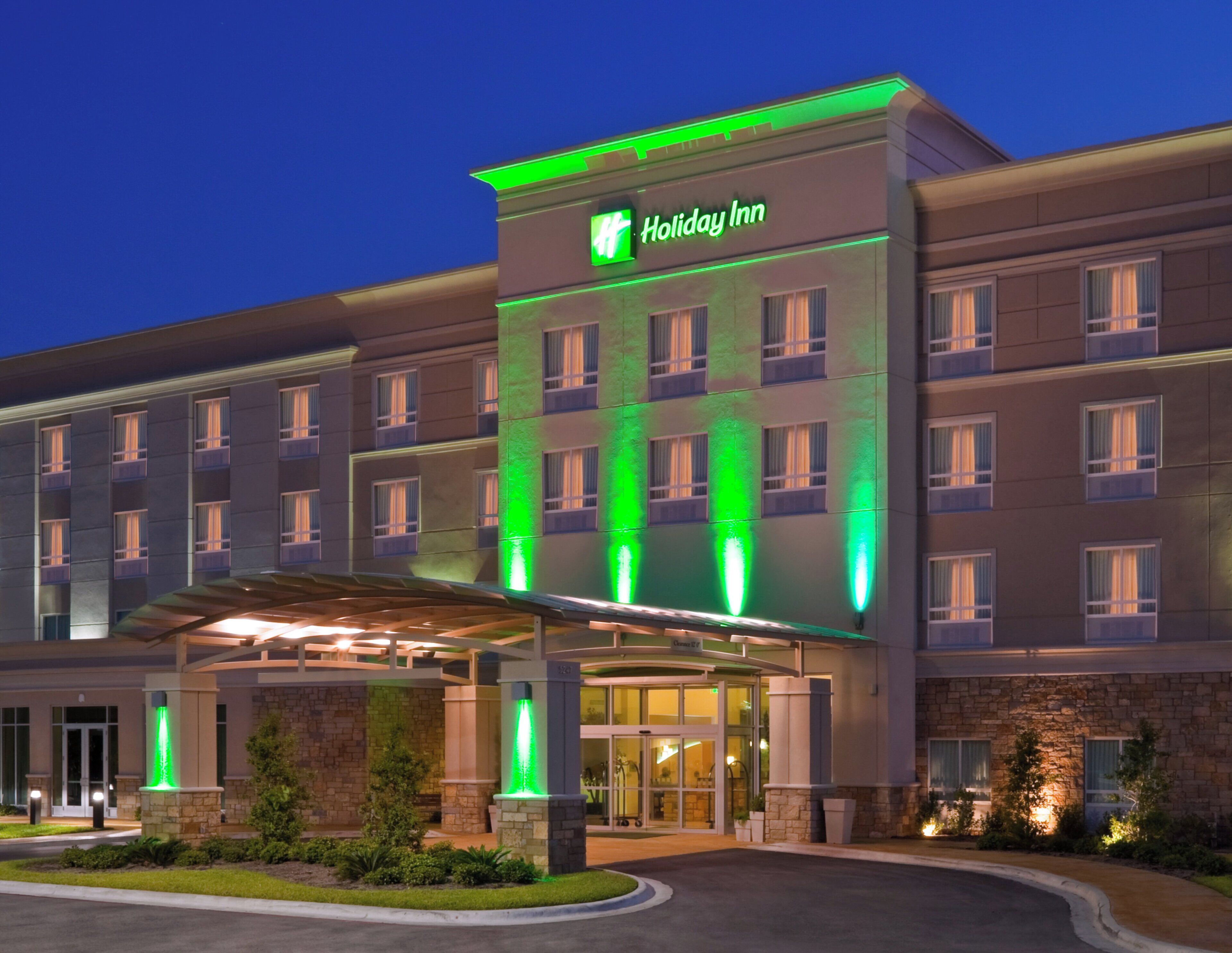 Um hotel Holiday Inn com fachada moderna, vários andares e uma entrada destacada.