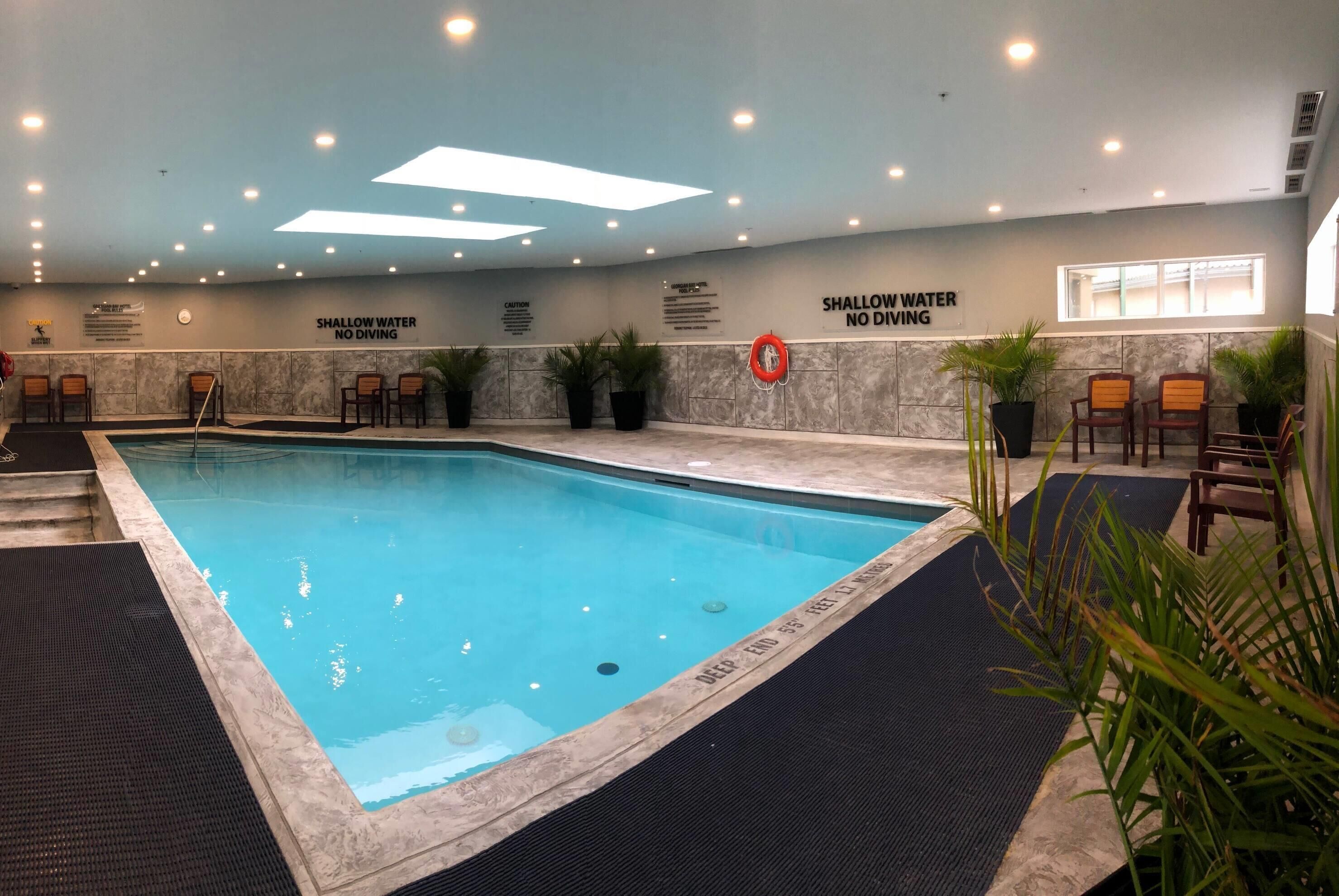 Piscina interna com sinalização clara indicando área rasa e proibição de mergulho.