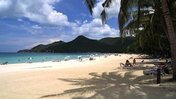 Na praia, guarda-sóis de praia, toalhas de praia