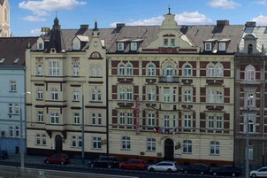 Um hotel histórico com vários andares, janelas amplas e um letreiro chamativo com a palavra 'HOTEL'.