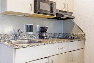 Um frigorífico/congelador grande, um micro-ondas, uma placa de cozinha 