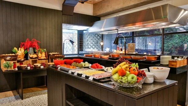Buffet com diversos pratos e vista para a cozinha.