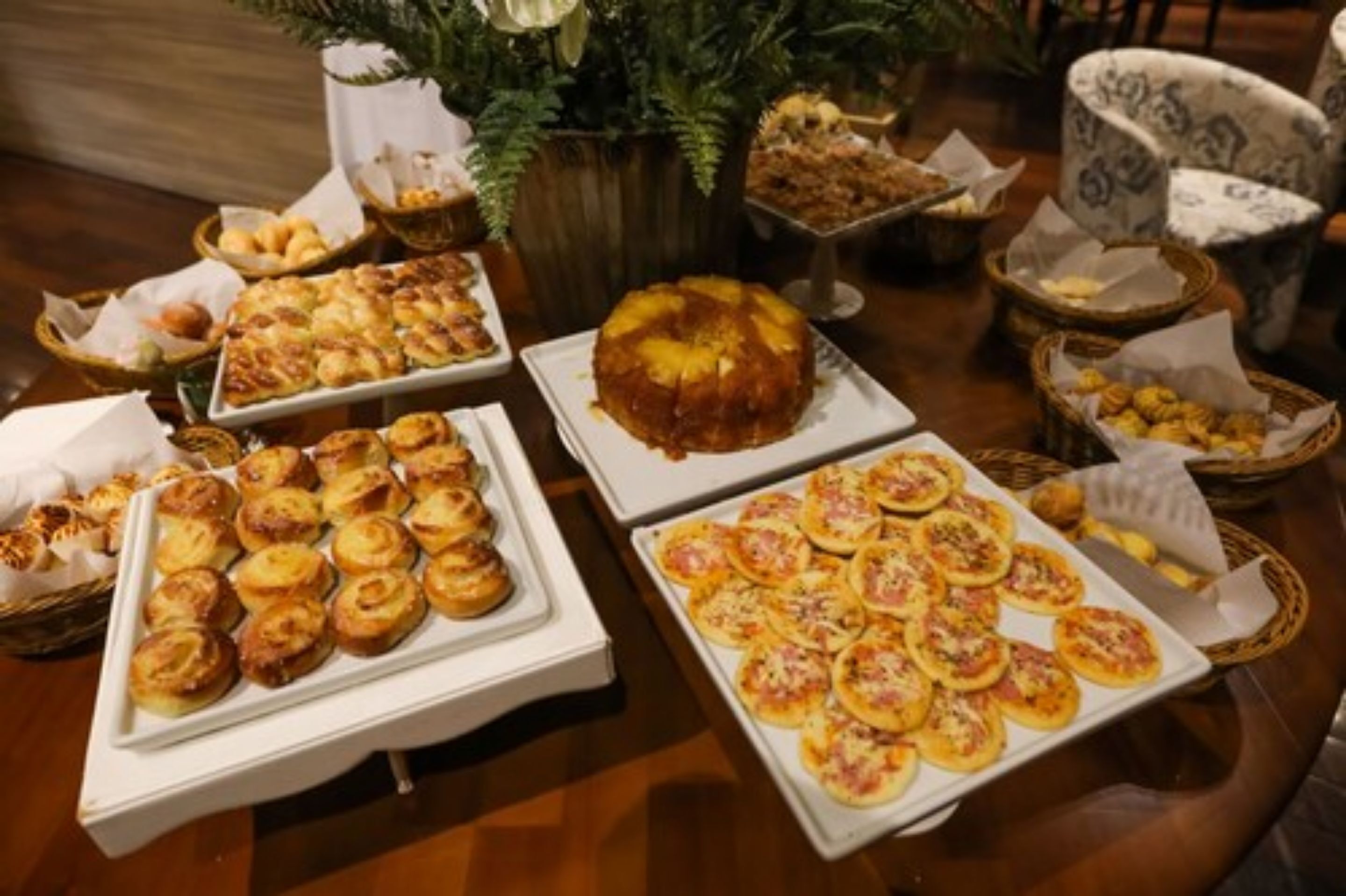 Uma mesa de buffet com diversos pães e doces.