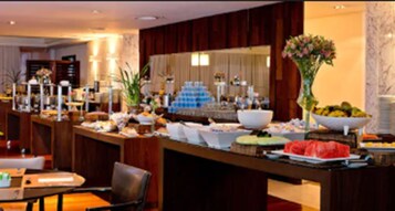 Disposição de buffet com diversos alimentos e um arranjo decorativo.