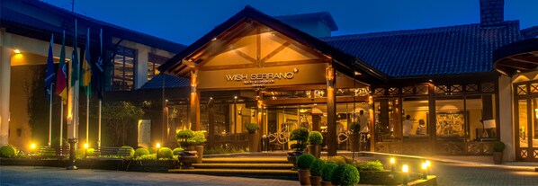 Entrada de um hotel com uma placa que diz 'WISH SERRANO RESORT & CONVENTION GRAMADO'.