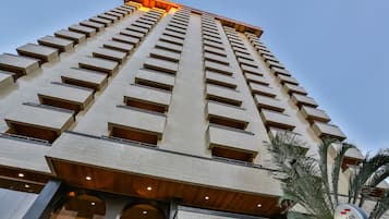 Um hotel alto com design moderno, apresentando uma placa destacada do San Marino Suite Hotel.