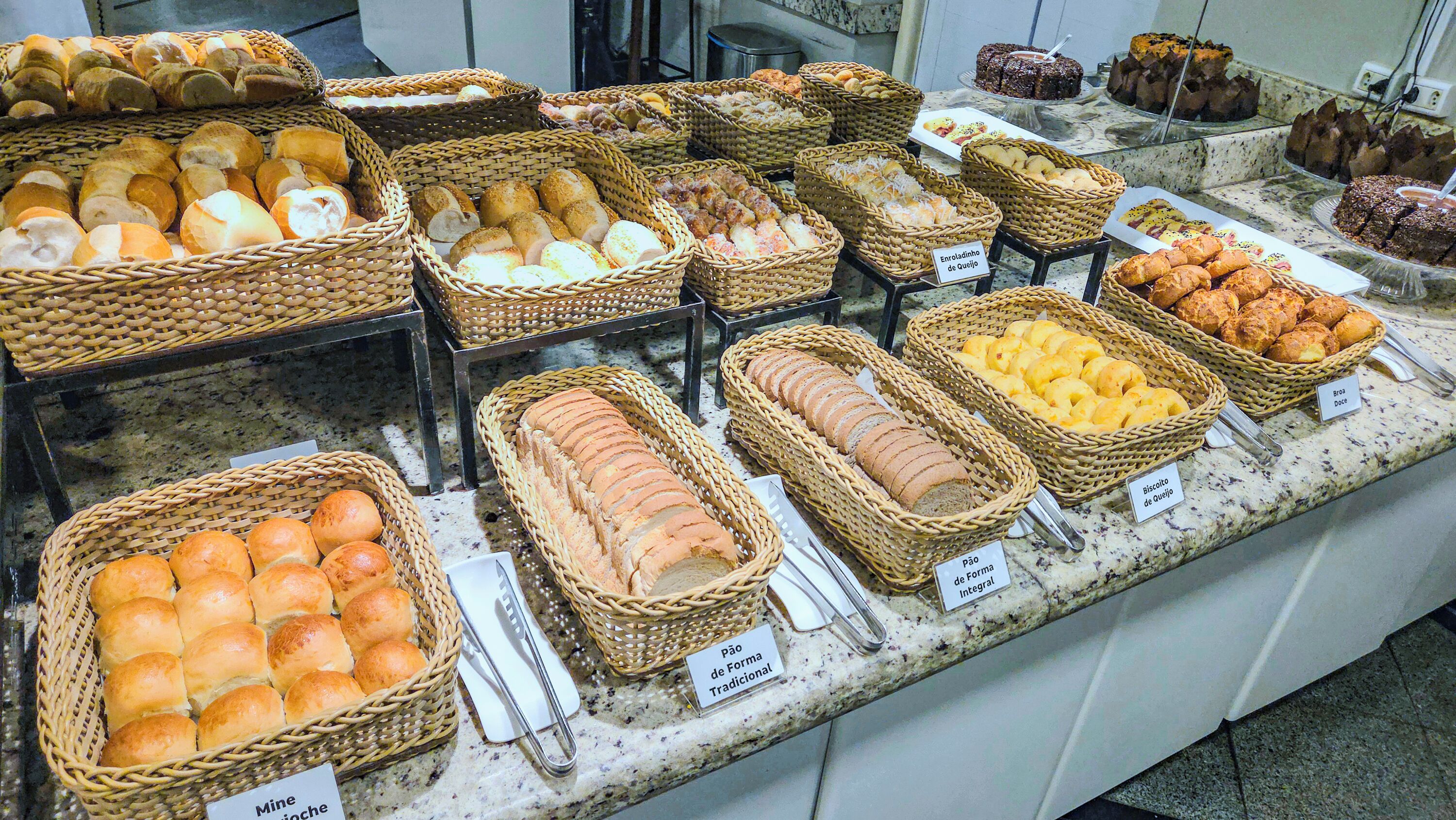Vitrine de padaria com diversos pães e doces.