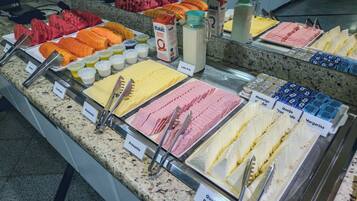 Buffet com diversos alimentos e utensílios.