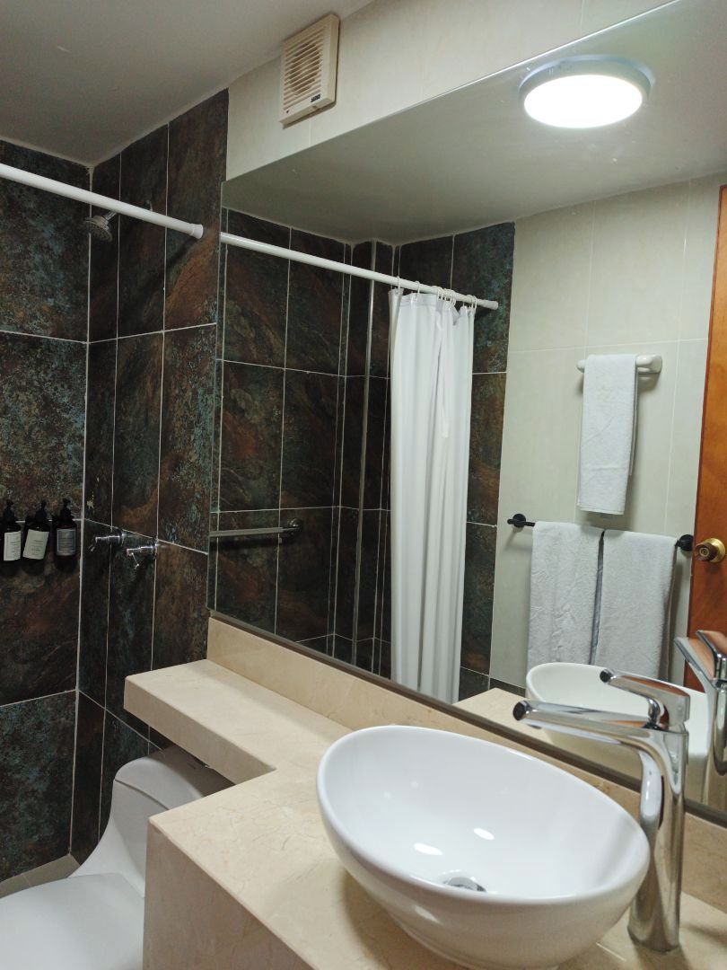 Uma casa de banho moderna com uma grande pia, um chuveiro com porta de vidro e um espelho sobre a pia.