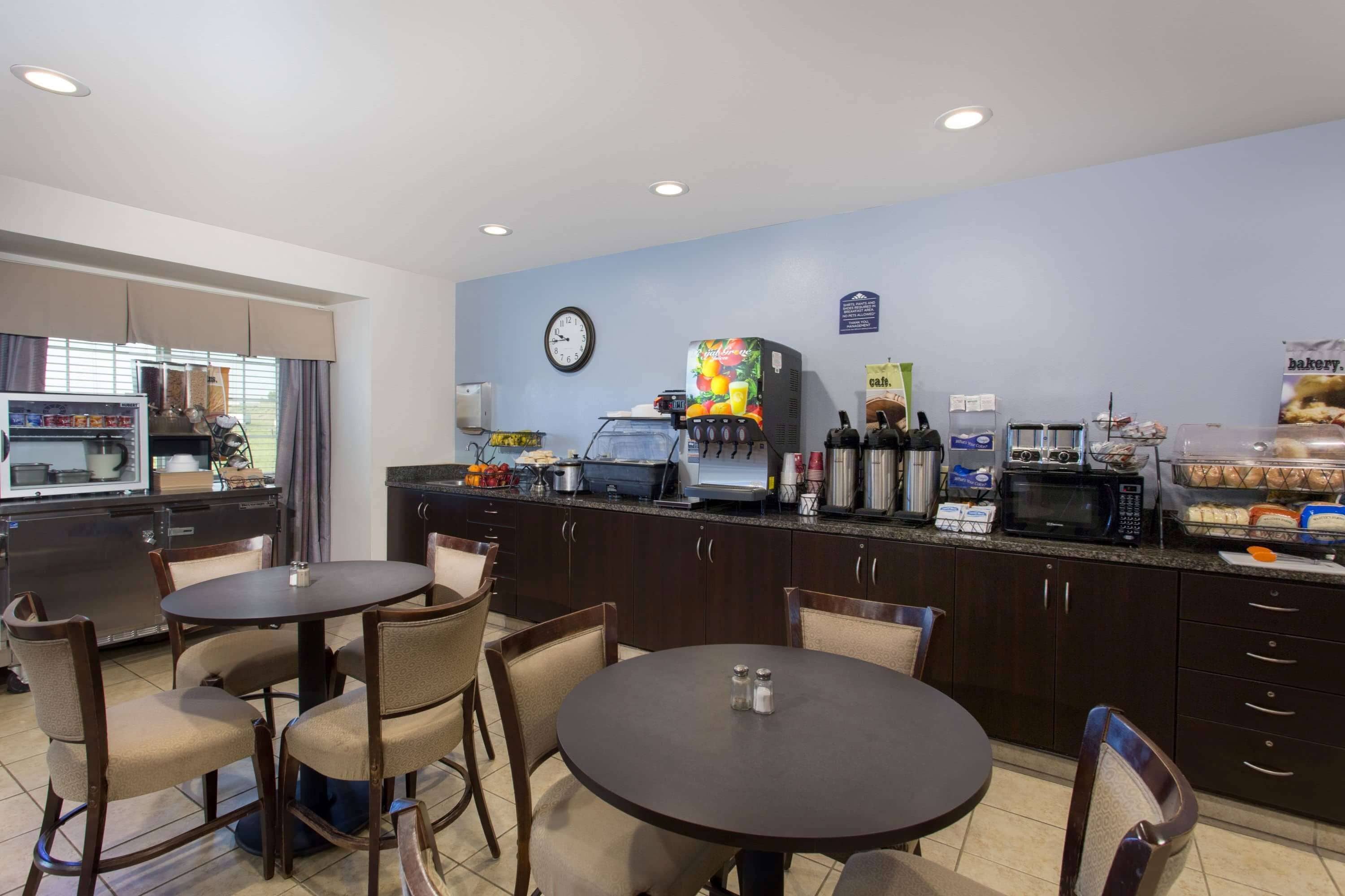 Cozinha moderna com cafeteira, micro-ondas e diversos alimentos.