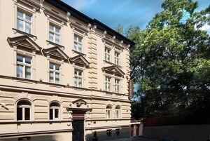 Um edifício clássico com várias janelas e uma placa com a inscrição 'ALEXANDER II'.