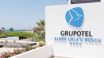 Placa de hotel com logotipo e o nome 'GRUPOTEL ALEDA CALA'N BOSCH'.