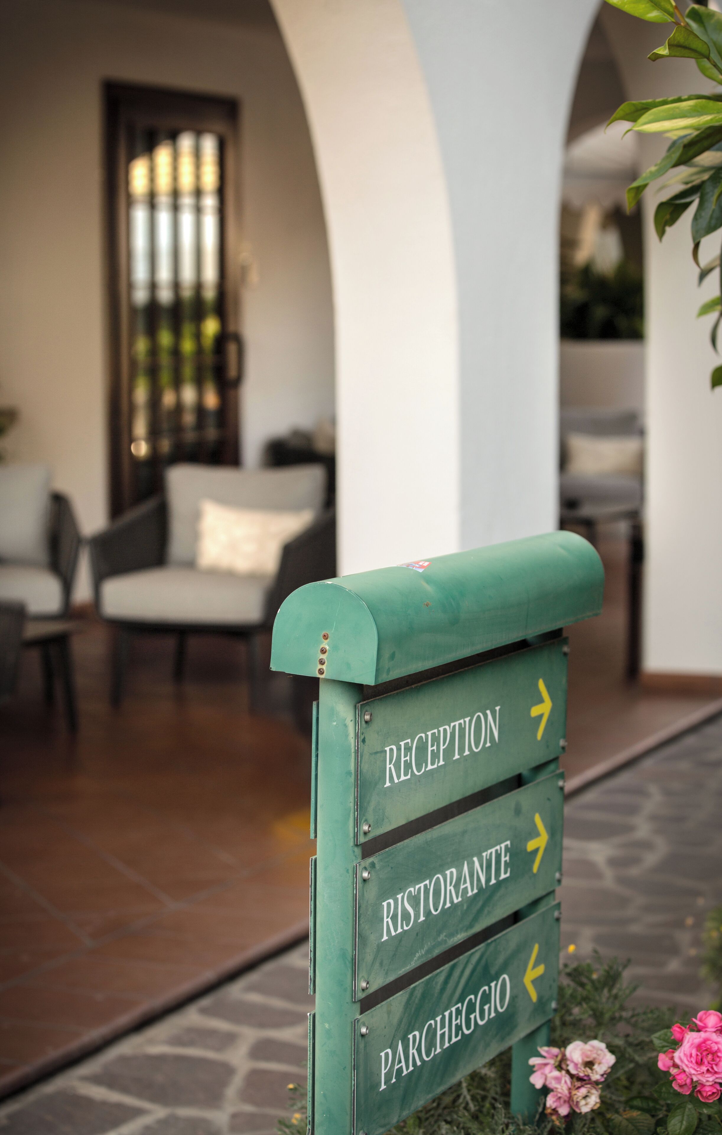 Placa de recepção com setas indicando a recepção, o restaurante e o estacionamento.