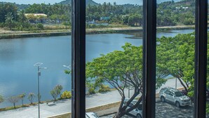 Vista de um lago, com uma área de estacionamento e árvores ao primeiro plano.