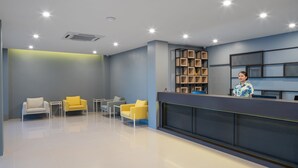 Uma área de recepção moderna com balcão, assentos e estante.