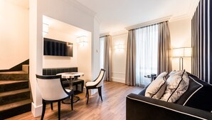 Uma sala de estar moderna com escada, área de jantar e sofá.