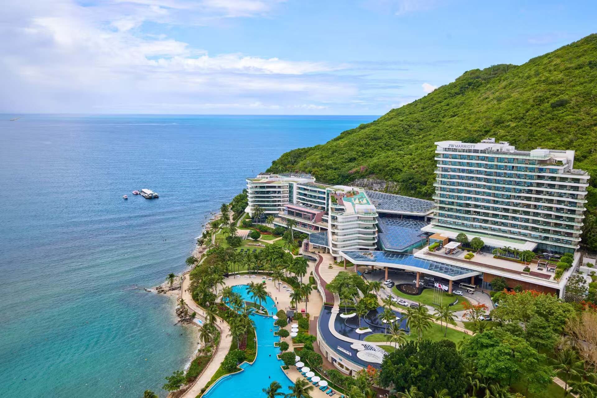 Um resort com vários edifícios, uma piscina e vista para o oceano.