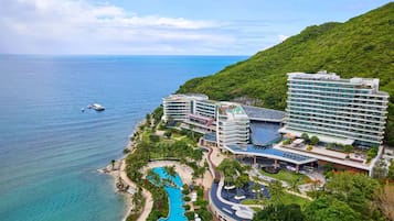 Um resort com vários edifícios, uma piscina e vista para o oceano.