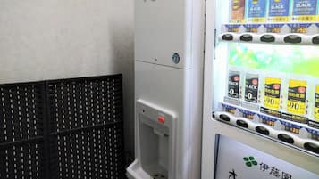 Máquina automática com seleção de bebidas e um bebedouro.