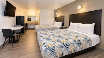 Quarto de hotel com duas camas, uma escrivaninha e uma cadeira.