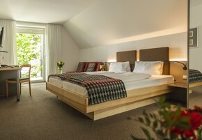 Quarto moderno com uma cama grande, uma escrivaninha e uma cadeira.