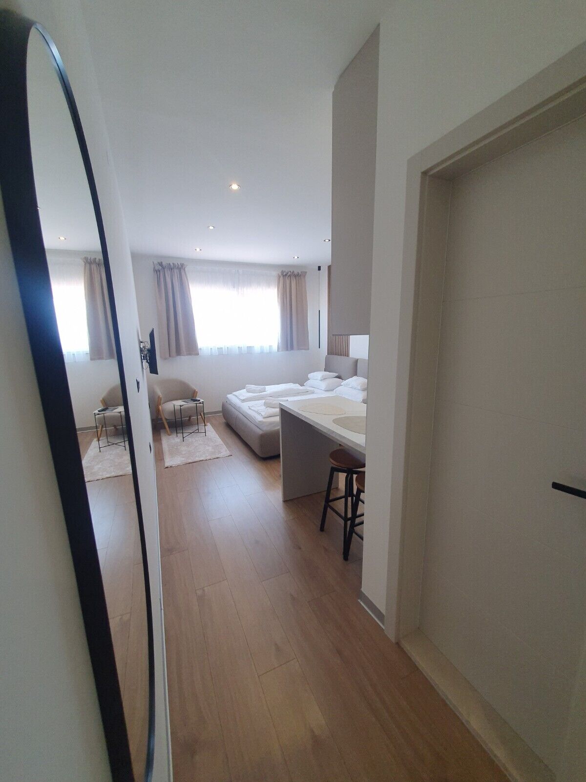 Quarto de hotel moderno com uma cama grande, uma escrivaninha e uma cadeira.