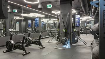 Uma academia moderna com diversos equipamentos de exercícios, incluindo esteiras, bicicletas ergométricas e aparelhos de musculação.