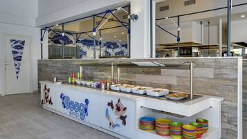 Uma área de buffet com um balcão branco, tigelas coloridas e um design com tema de cachorro.