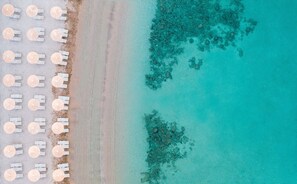 Na praia, espreguiçadeiras, guarda-sóis de praia, toalhas de praia 