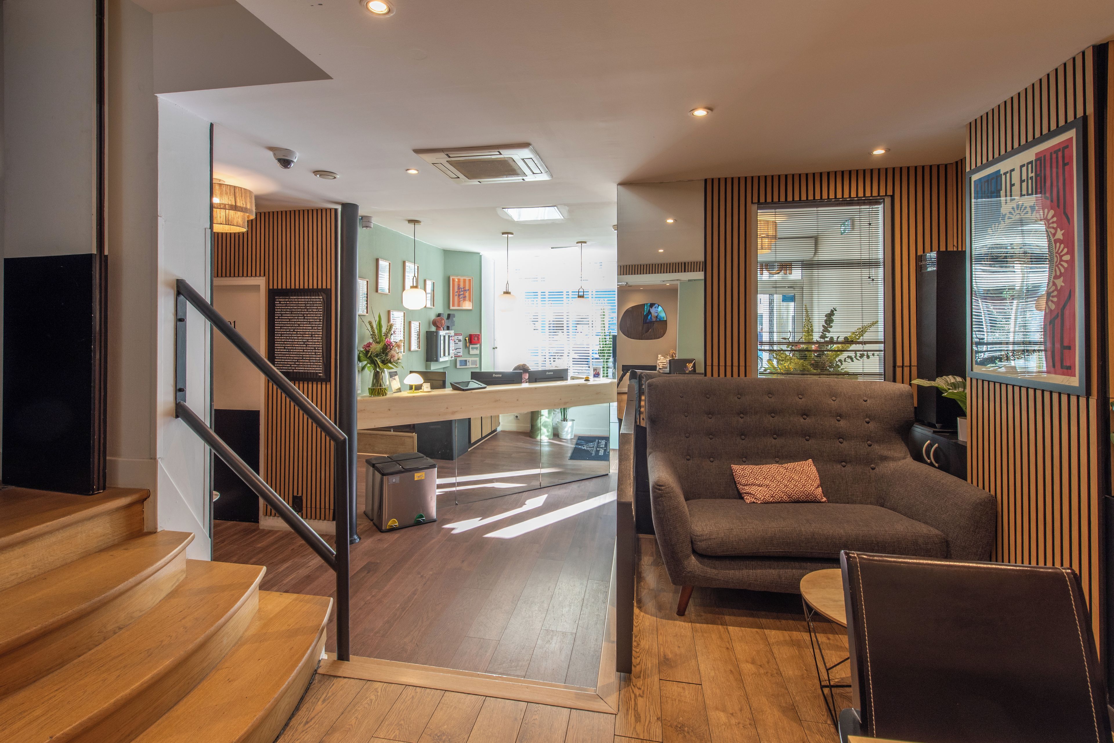 Um interior moderno com uma escada que leva a uma sala de estar, um sofá e uma mesa de jantar.