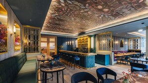 Interior moderno de restaurante com área de bar, disposição de assentos e decoração no teto.