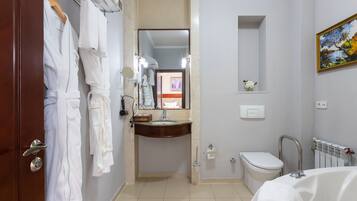 Casa de banho moderna com lavatório, sanita e banheira.