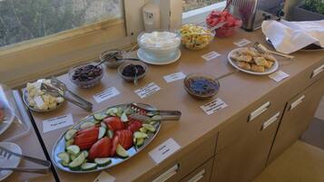Uma mesa de buffet com diversos alimentos e utensílios.
