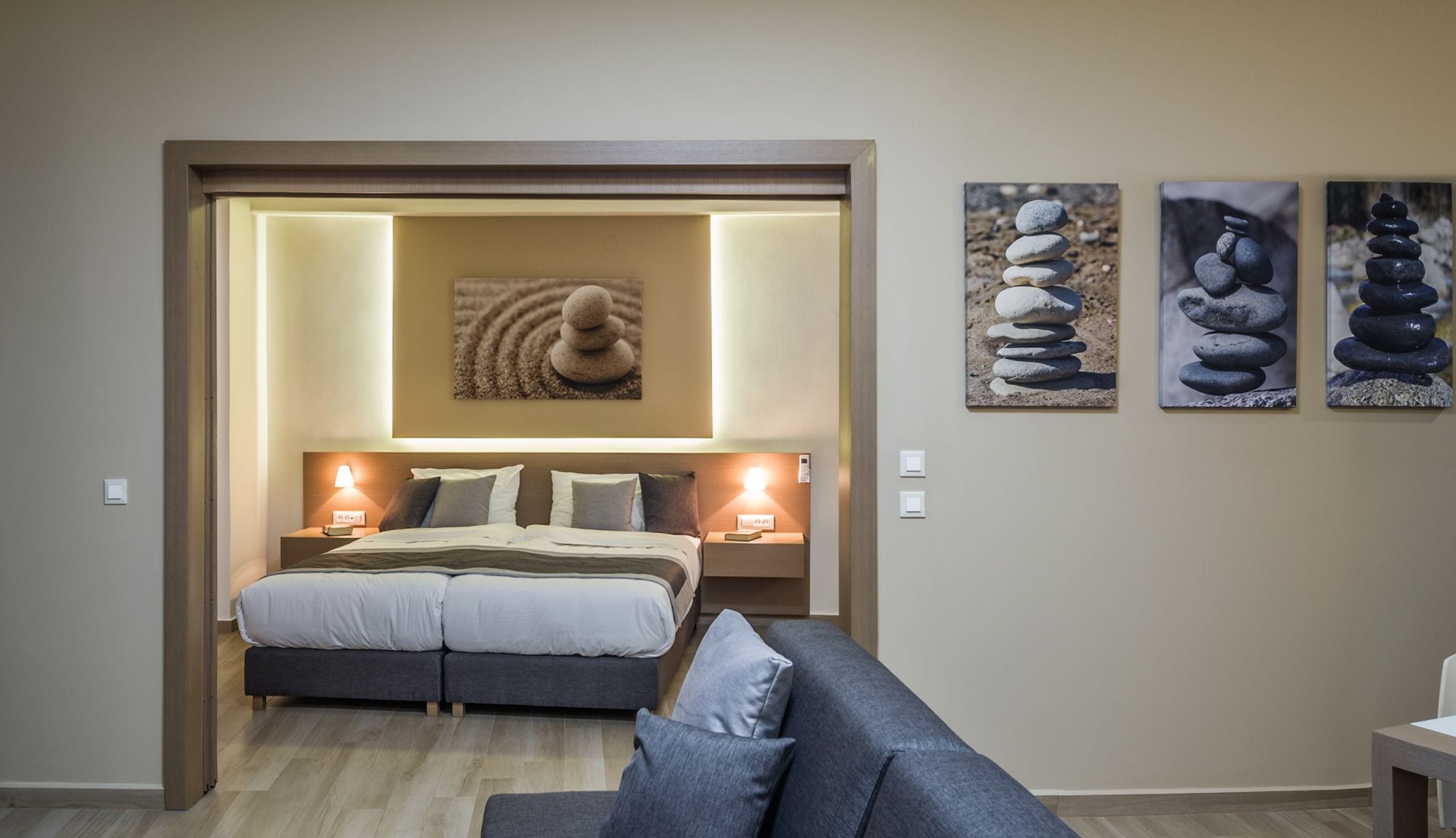 Um quarto com uma cama, abajures, uma obra de arte na parede e três quadros.