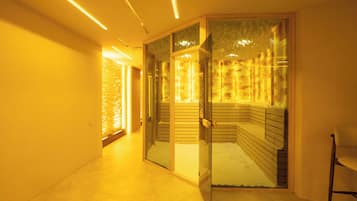 Corredor com porta de vidro que dá para uma área de sauna.