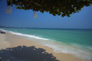Praia particular, areia branca, espreguiçadeiras, guarda-sóis 