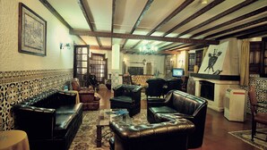Uma sala de estar tradicional com sofás de couro, lareira e televisão.