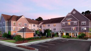 Um hotel TownePlace Suites Marriott com estacionamento e uma placa de parada.