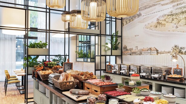 Buffet com diversos alimentos e um mural na parede.