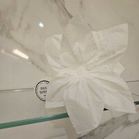 Toalha branca com um laço sobre uma superfície de mármore.