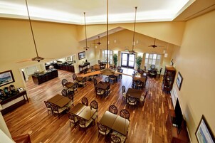 Uma sala de jantar espaçosa com piso de madeira e várias mesas e cadeiras.
